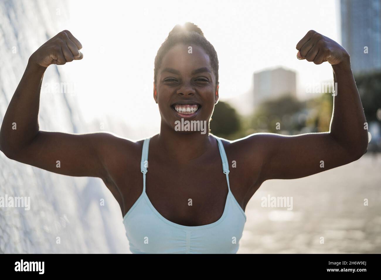 Happy african woman doing workout routine outdoor in the city - Focus ...