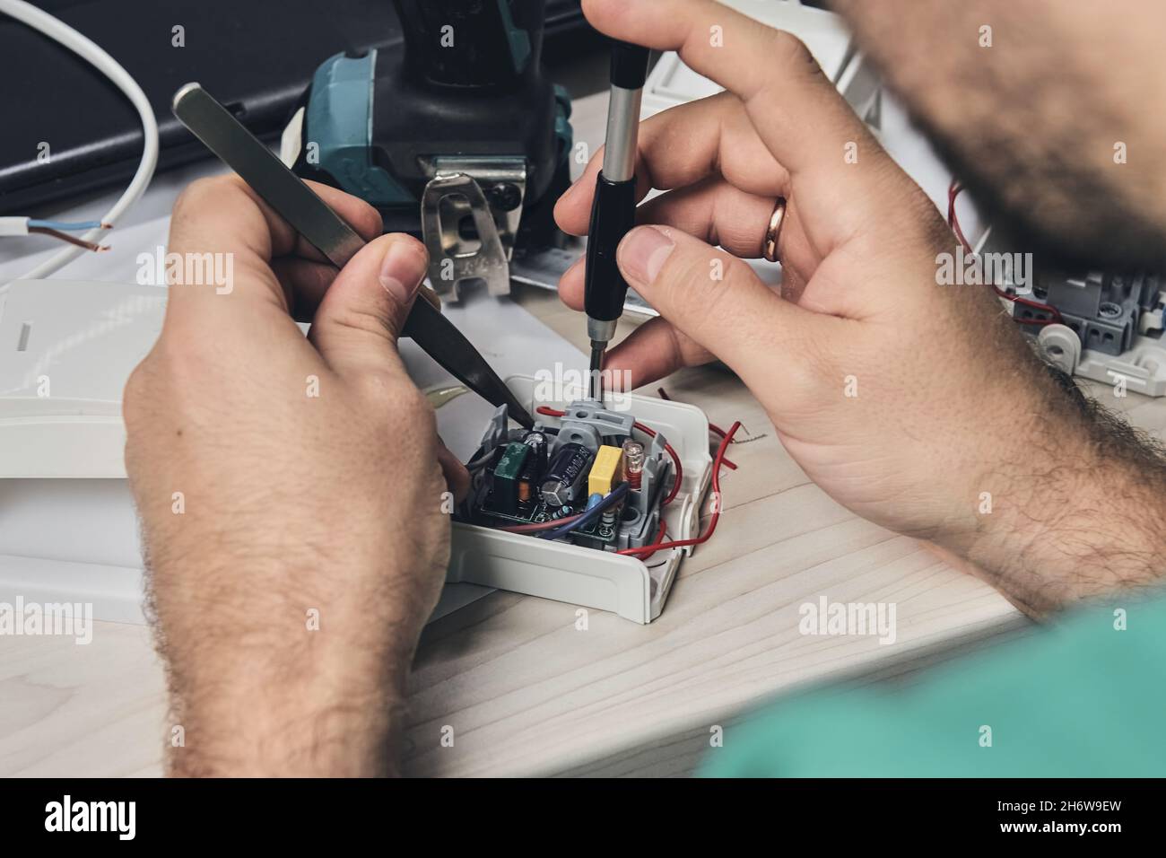 Repair of electronic devices, tin soldering parts. Hands of man holding ...