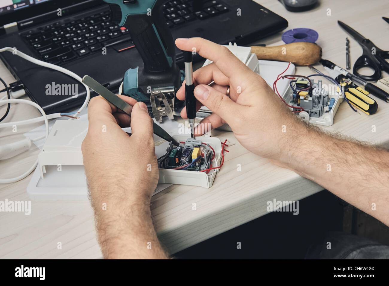 Repair of electronic devices, tin soldering parts. Hands of man holding ...
