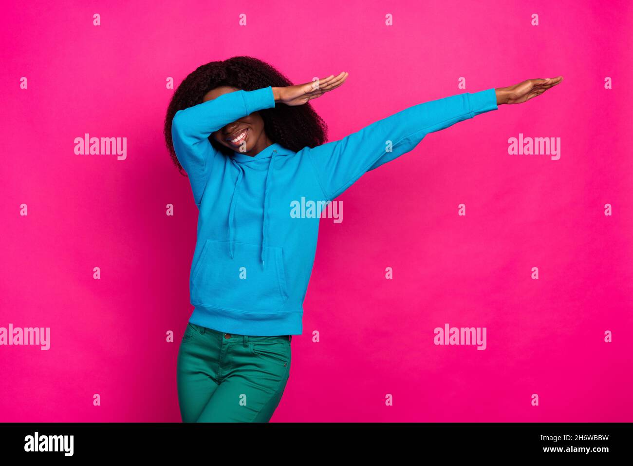 Photo portrait of woman smiling showing dab sign in blue hoody isolated ...