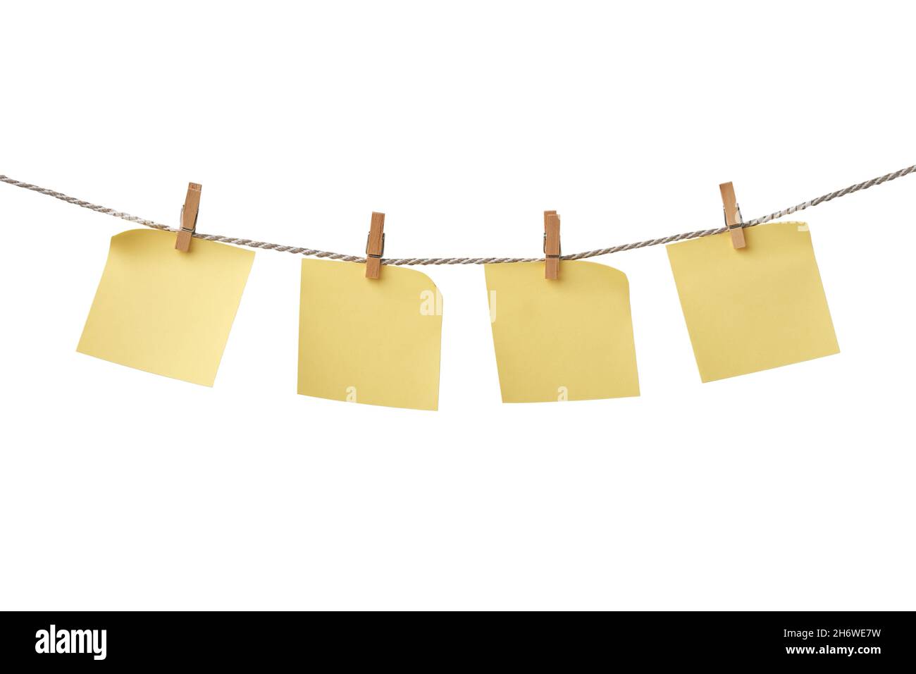 Four yellow paper blank notes hanging on the rope isolated on white ...