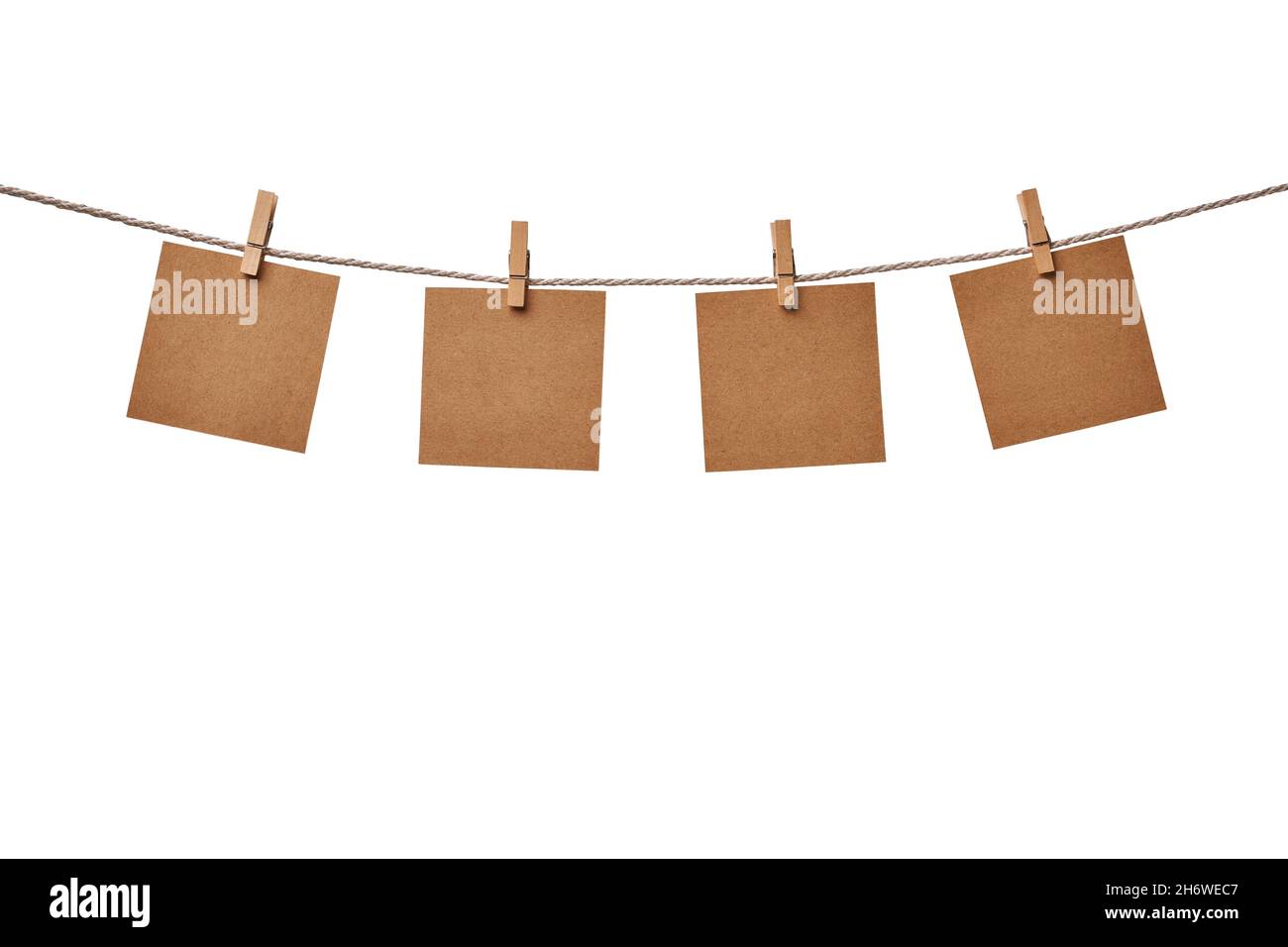 Four craft paper blank notes hanging on the rope with wooden ...