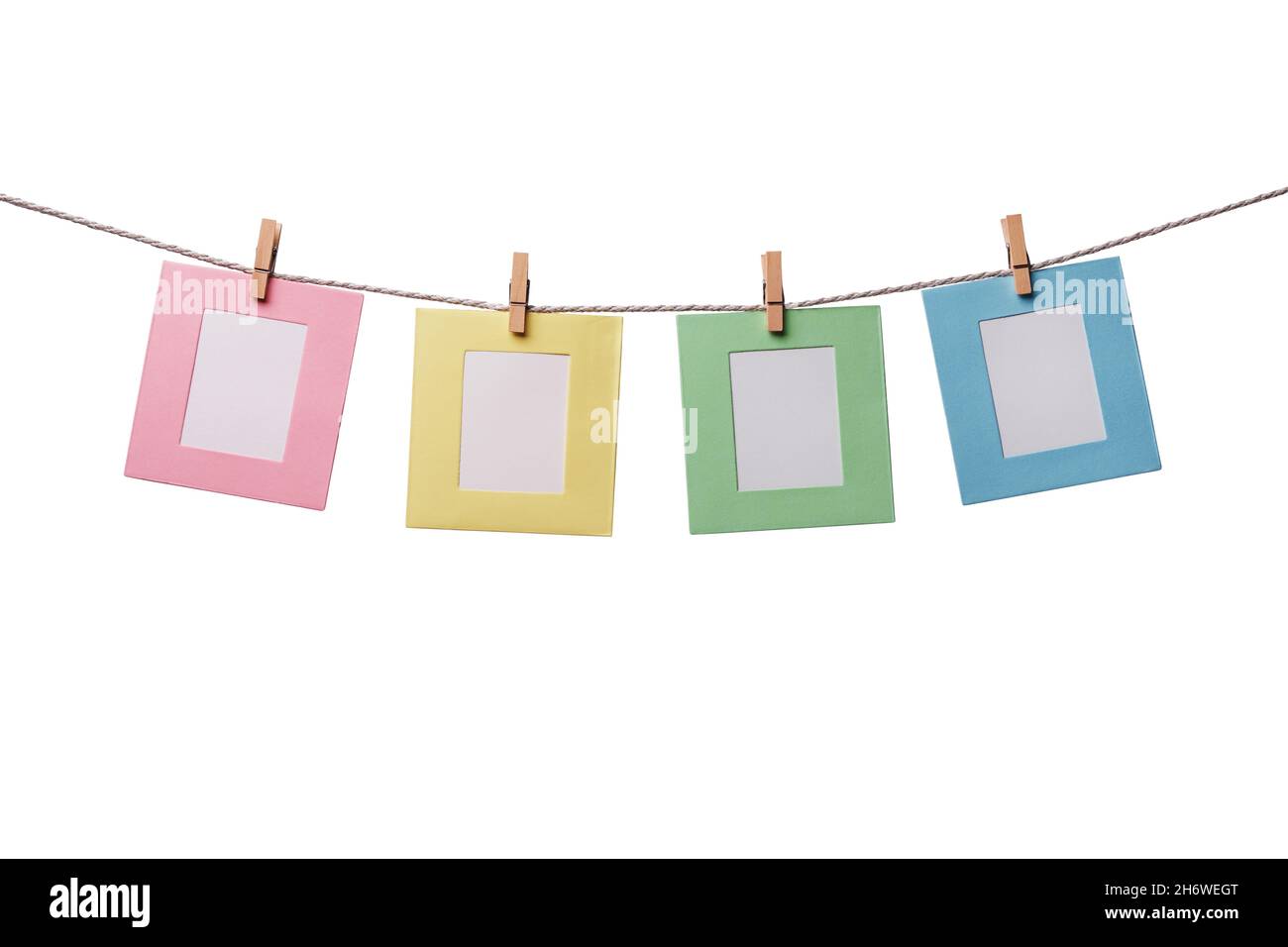 Four colorful paper photo frames hanging on the rope isolated on white ...