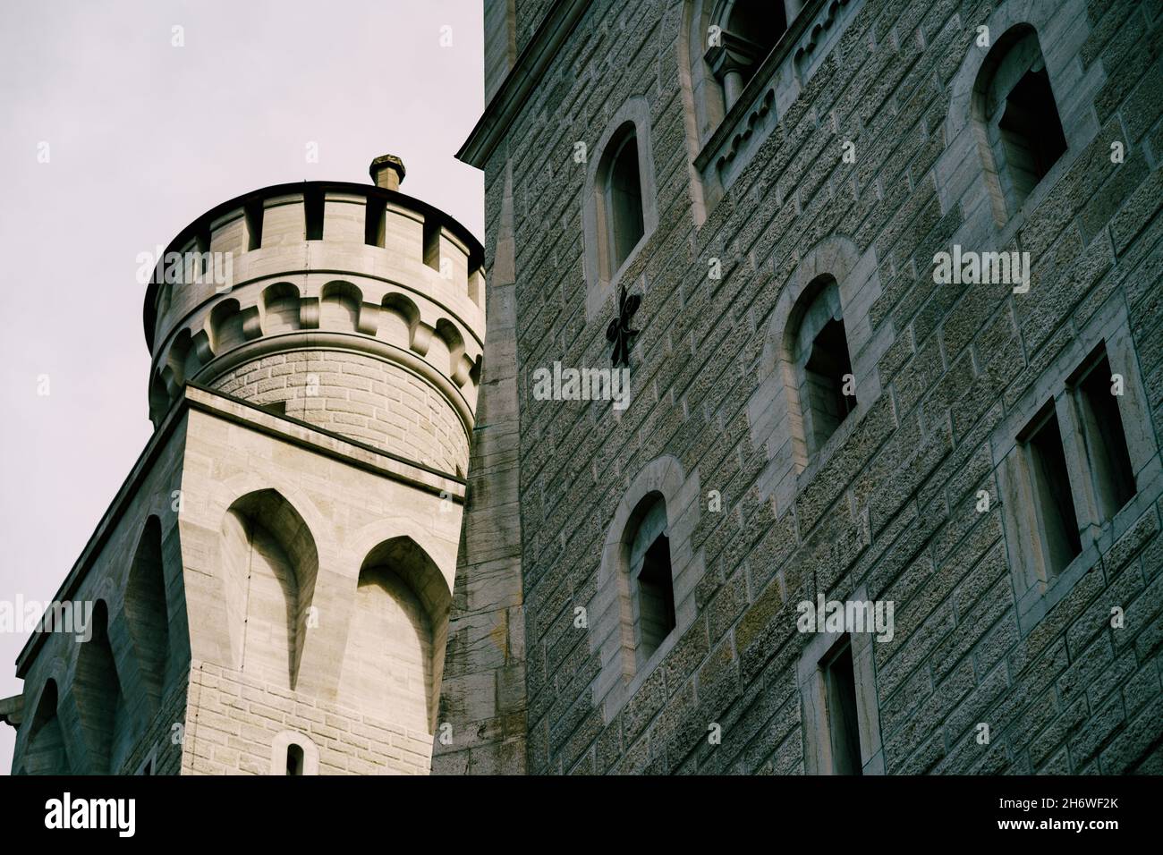 Facade of Neuschwanstein Castle with loophole windows and a round tower ...