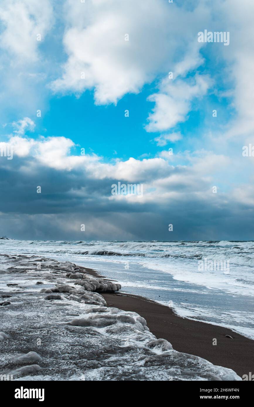 Winter landscape with frozen sea and icy beach. Storm and snow weather ...