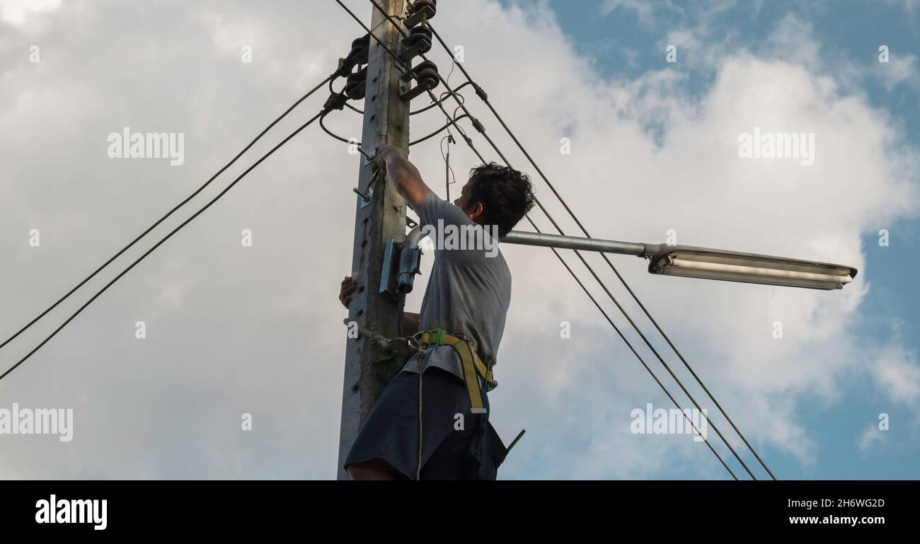 Electrician, repairman are climbing and work on electric pole. Concept ...