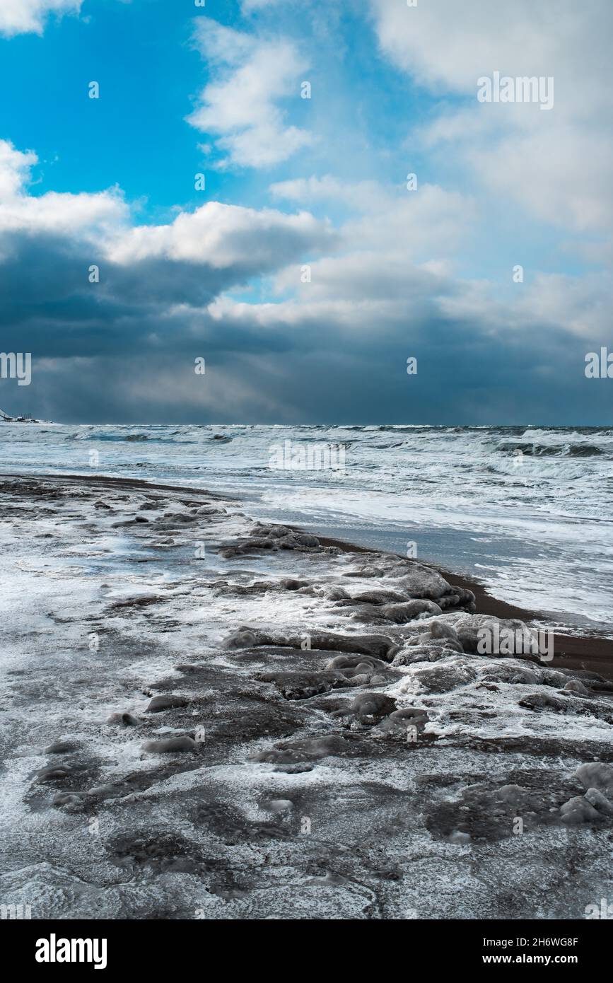 Winter landscape with frozen sea and icy beach. Storm and snow weather ...
