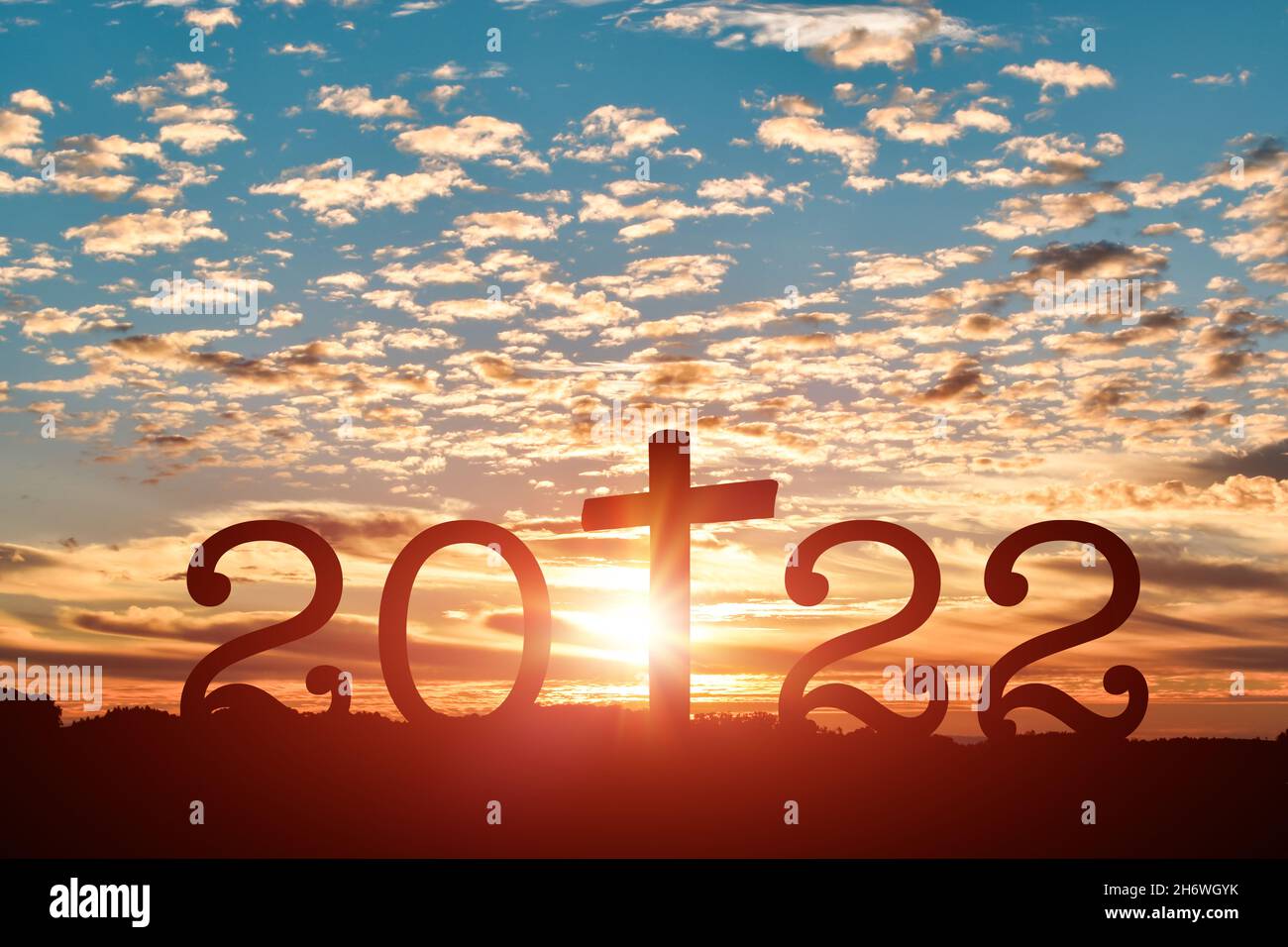 Silhouette of Christian cross with 2022 years at sunset background ...