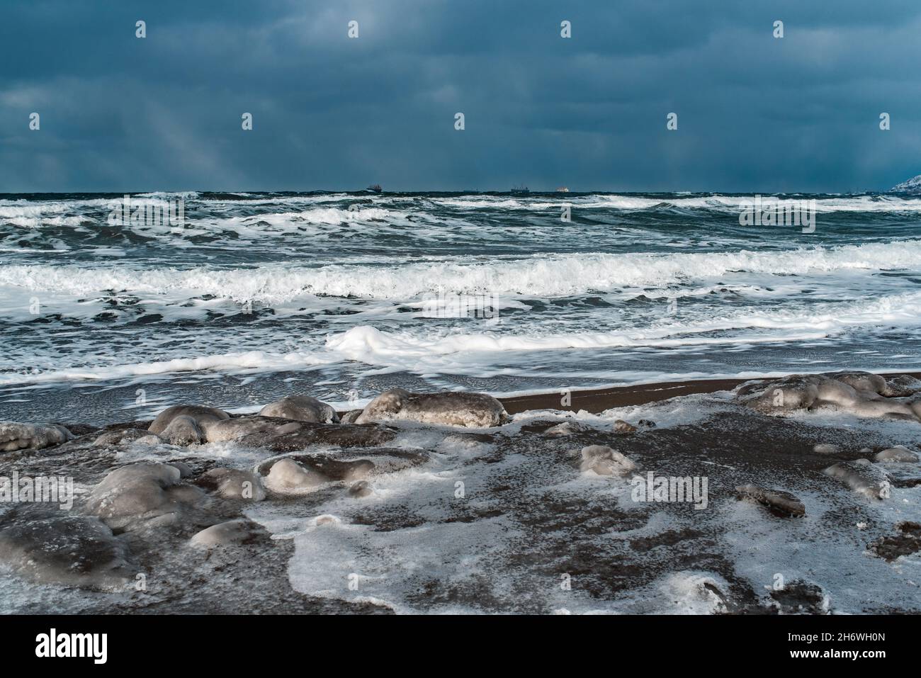 Winter landscape with frozen sea and icy beach. Storm and snow weather ...