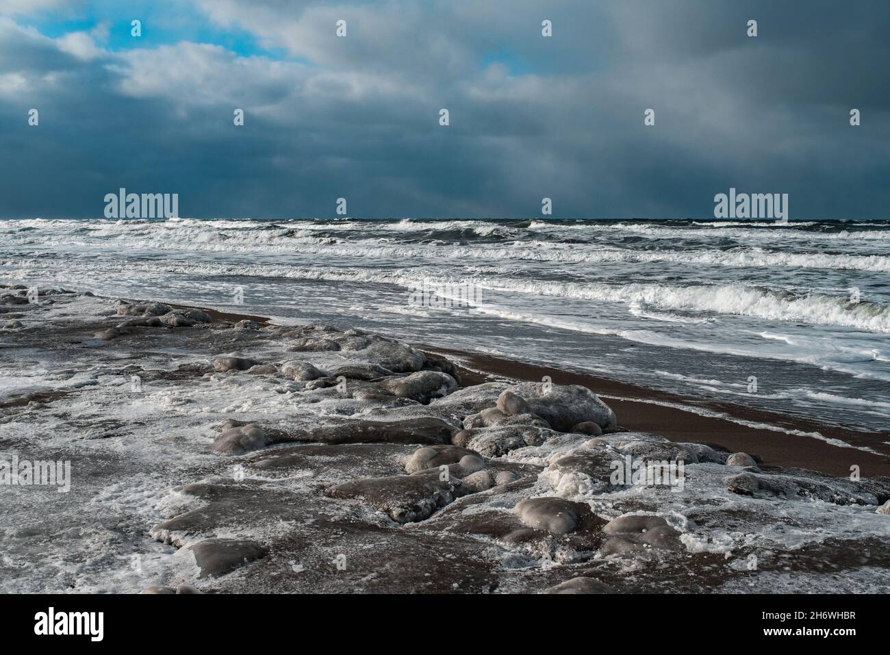 Winter landscape with frozen sea and icy beach. Storm and snow weather ...