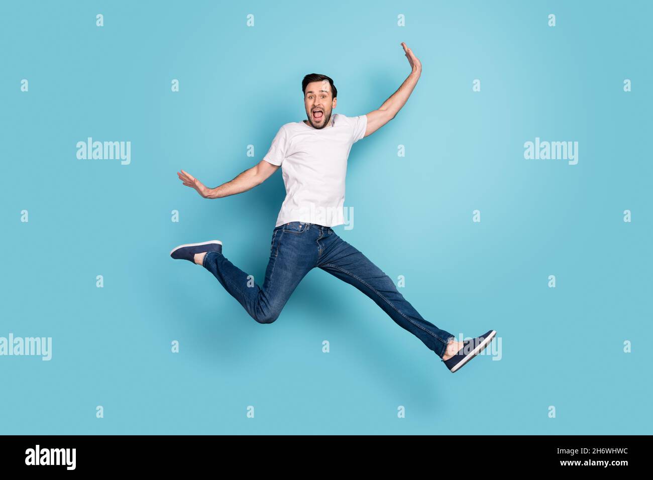 Full body photo of cheerful amazed young man jump up air raise hands ...