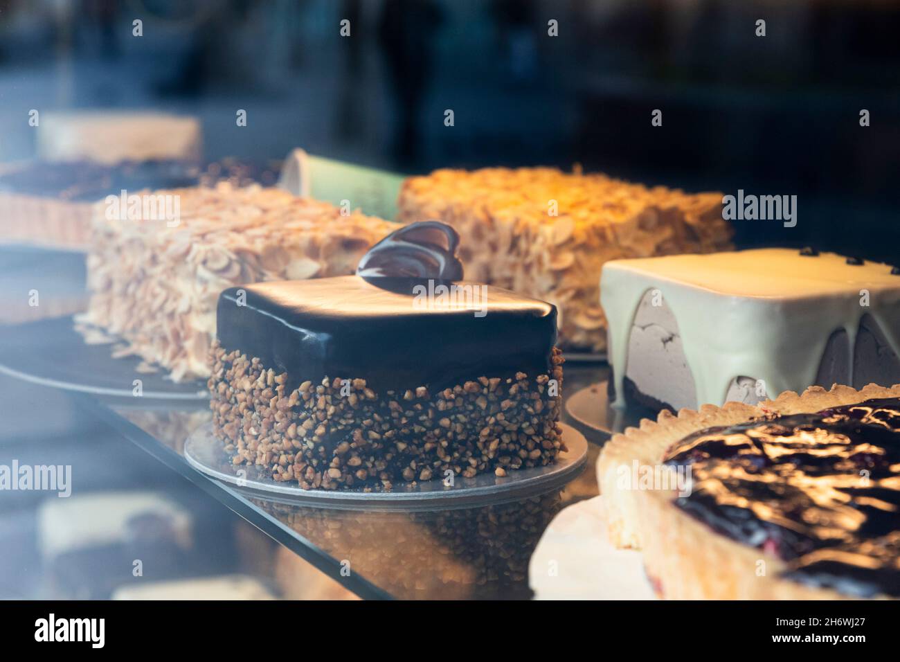 Different types of cakes in pastry shop glass display Stock Photo - Alamy
