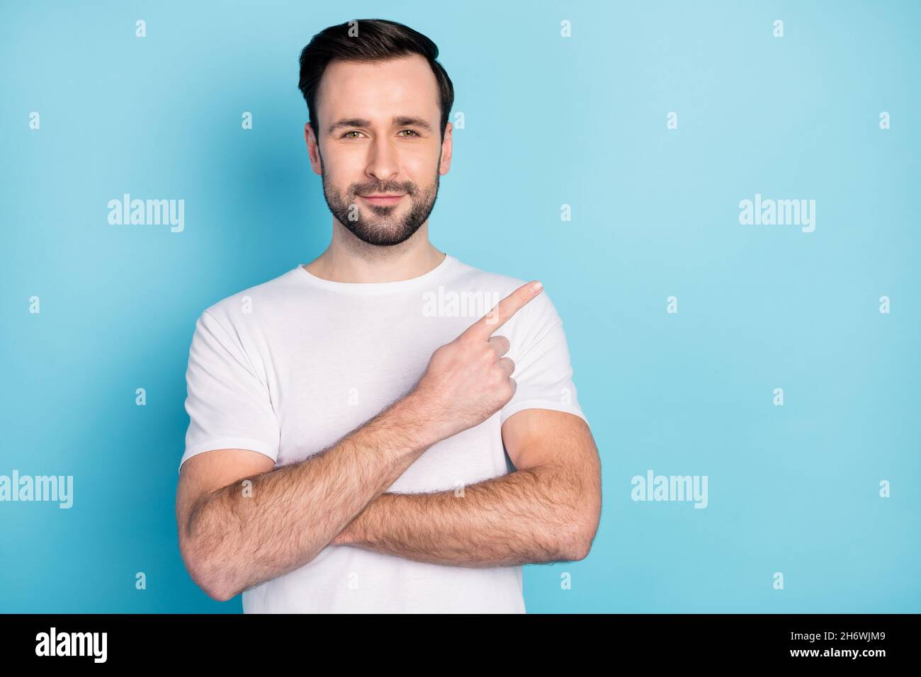 Portrait of friendly satisfied man direct finger empty space promotion ...