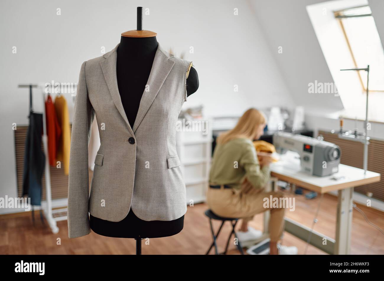 Jacket on mannequin, dressmaker at sewing machine Stock Photo - Alamy