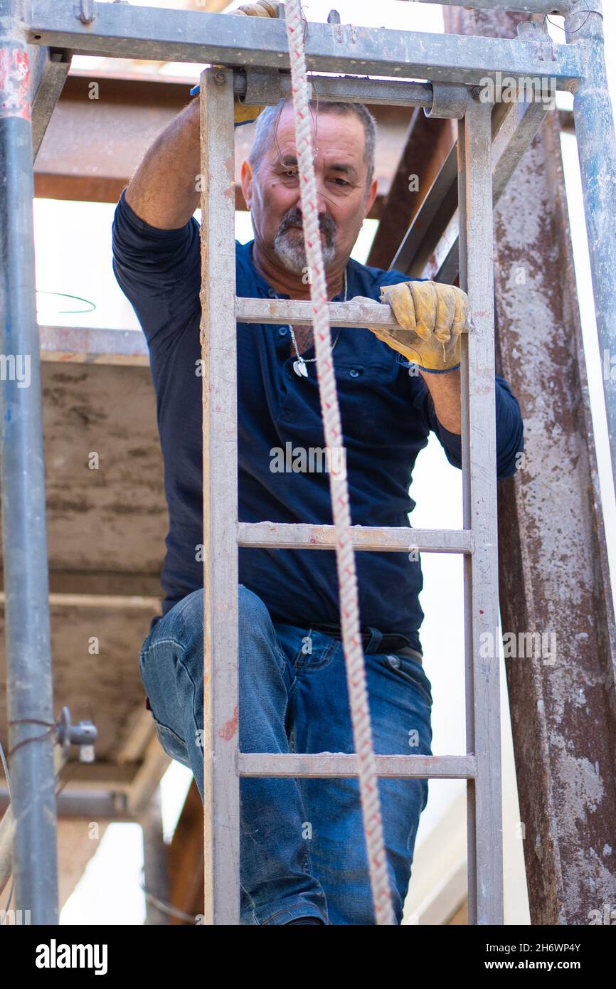 construction worker climbed on a ladder to repair the wall Stock Photo ...