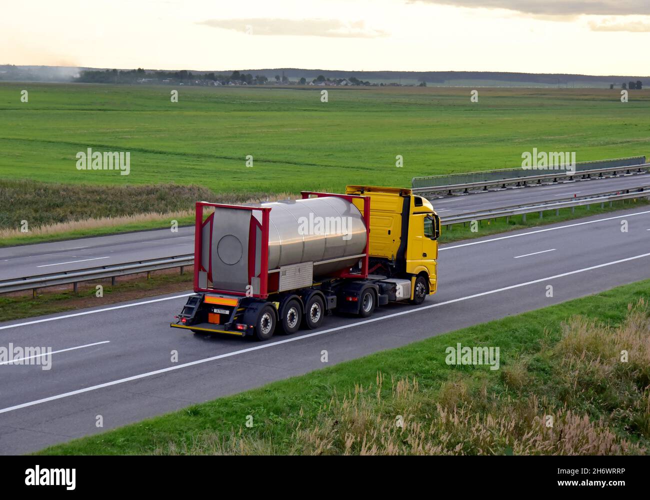Truck with tank container driving along highway. International bulk gas ...