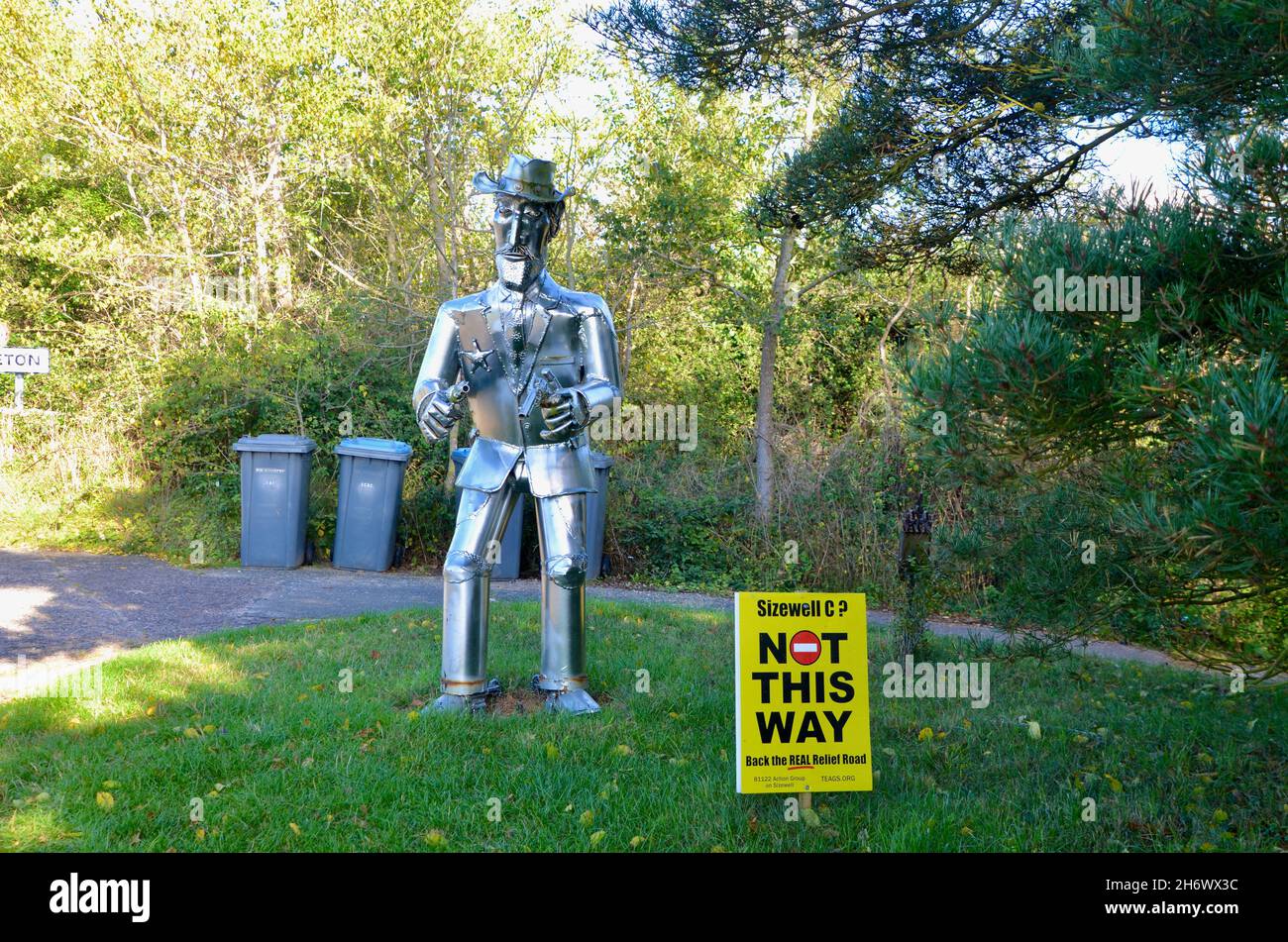 a large tin man painted silver and a not this way sign protesting at ...