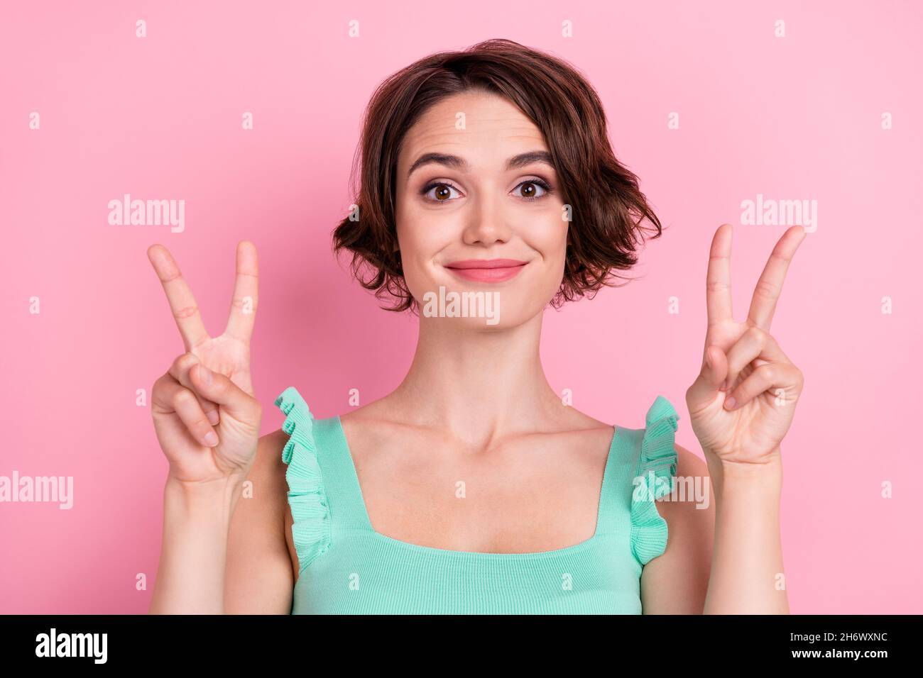 Portrait of attractive funny cheerful girl showing double v-sign ...