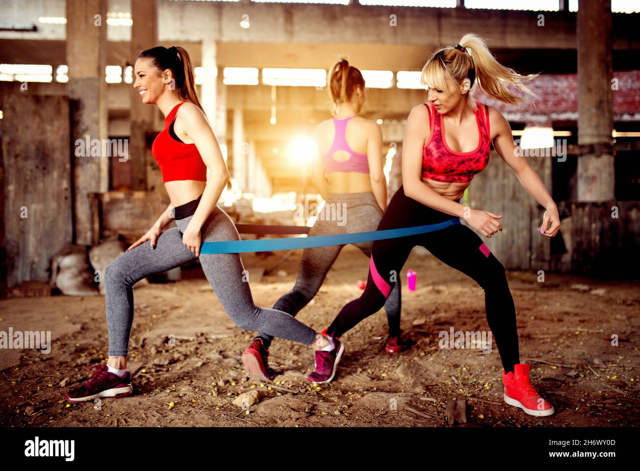 Group of fitness people stretching rope working out legs. Friends ...