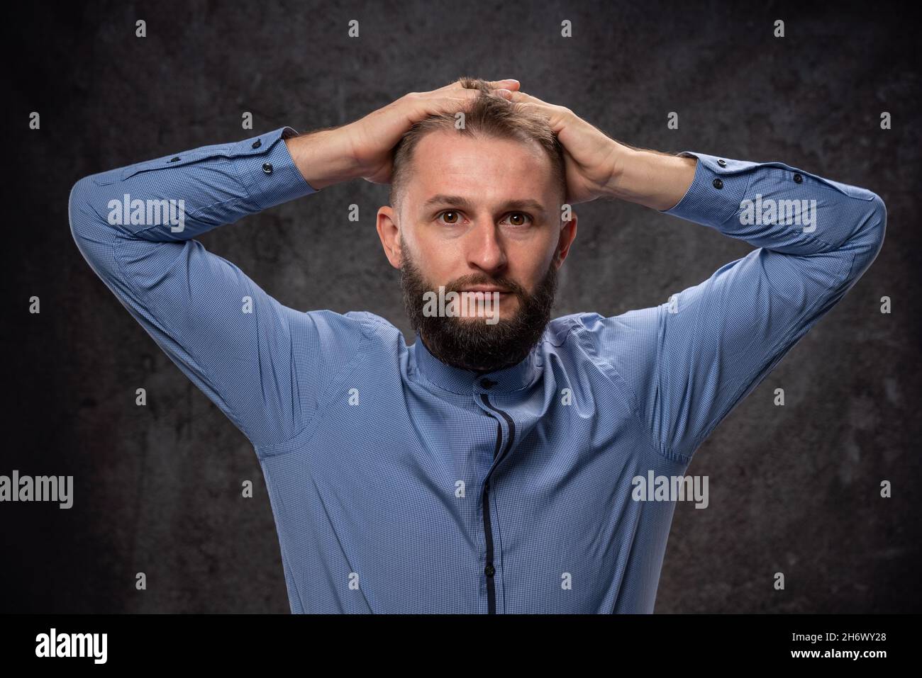 Emotionally shocked young man, holding his head with his hands ...
