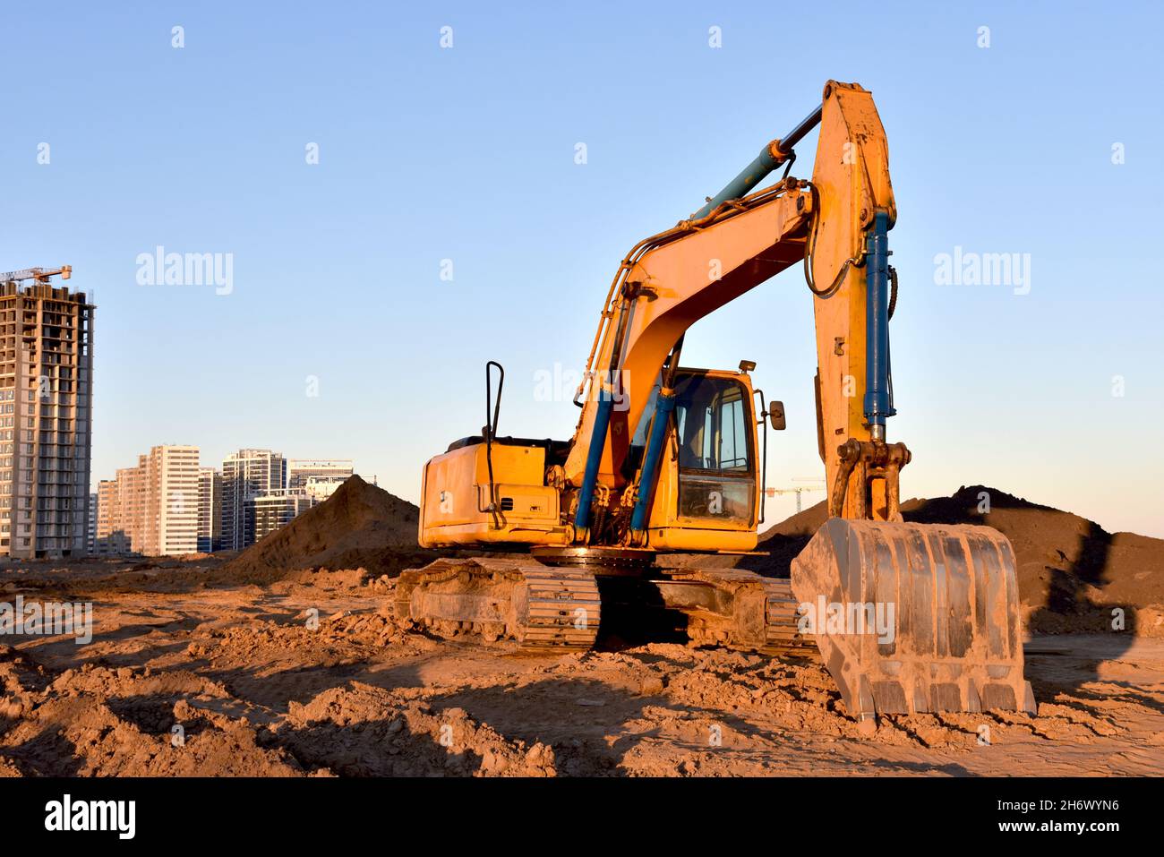Excavator working at construction site on earthworks. Backhoe on road ...