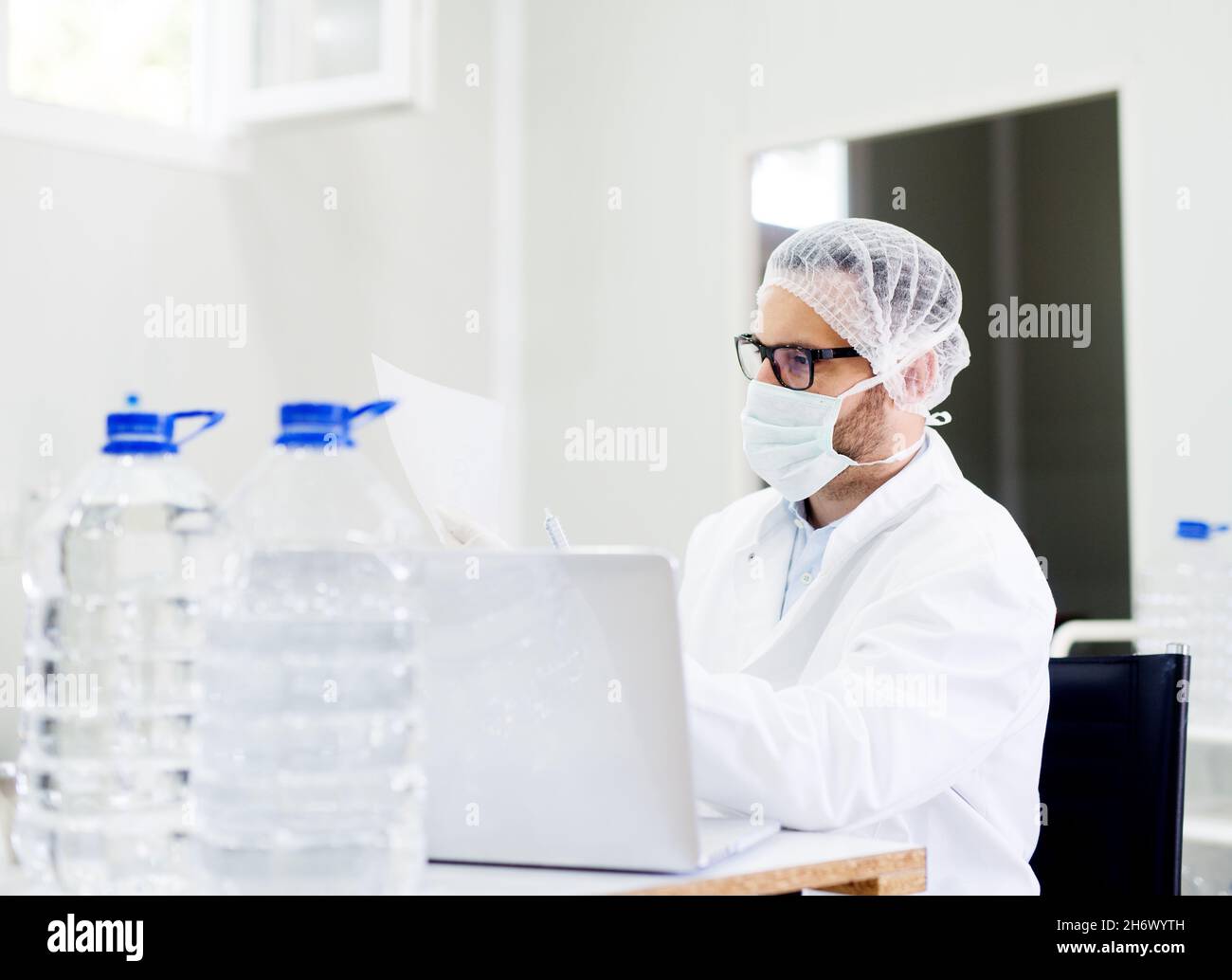 Male scientist writing report with equipment and science experiments ...