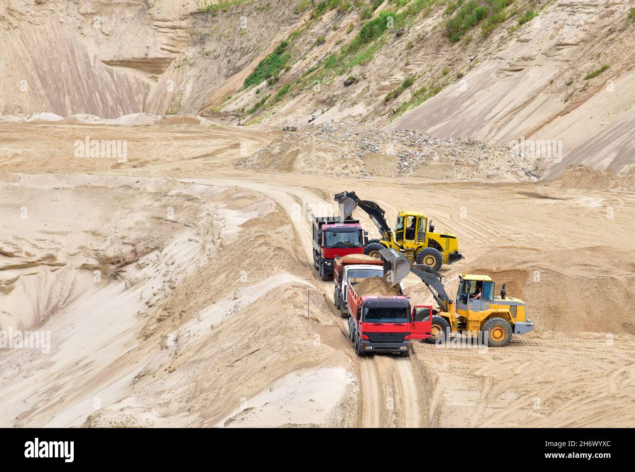 Wheel loader loading sand into heavy dump truck at the opencast mining ...