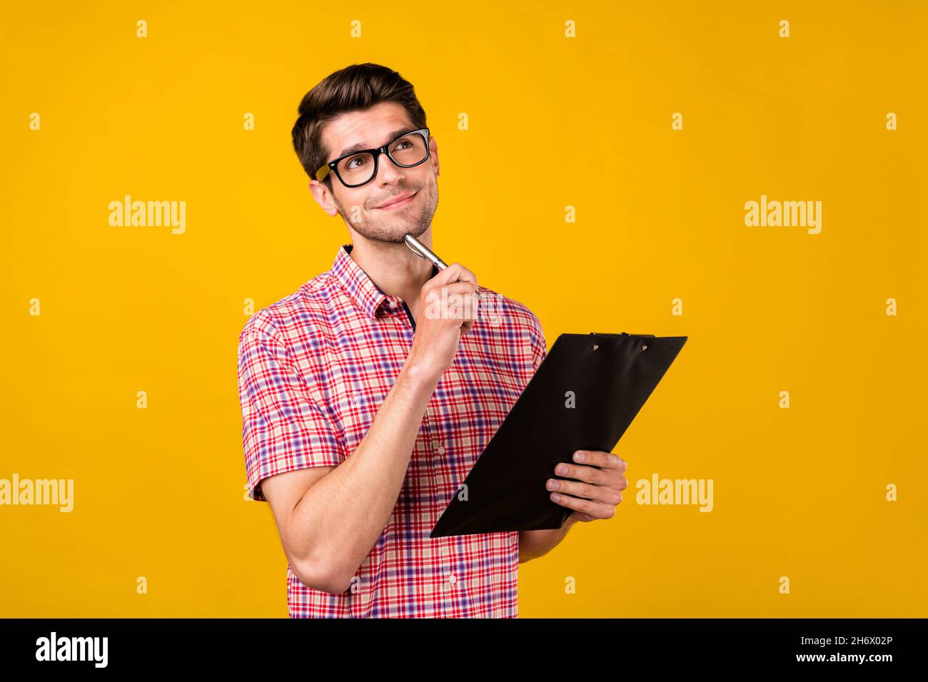 Portrait of attractive minded guy journalist thinking writing essay ...