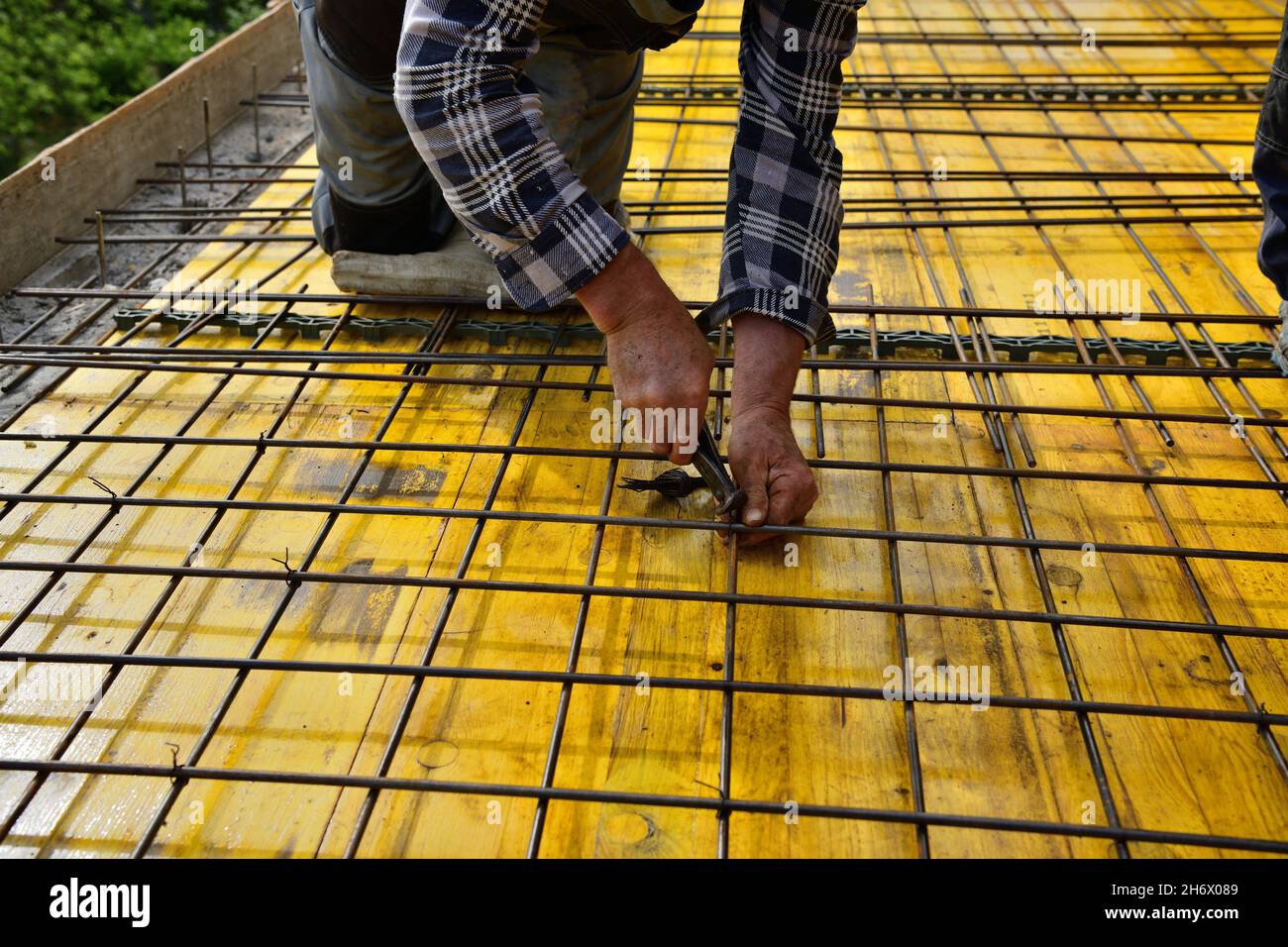The mason makes a wire reinforcement in preparation for concreting the ...