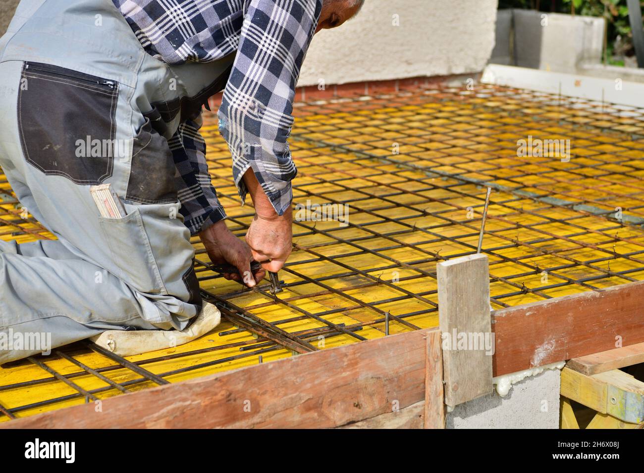 The mason makes a wire reinforcement in preparation for concreting the ...