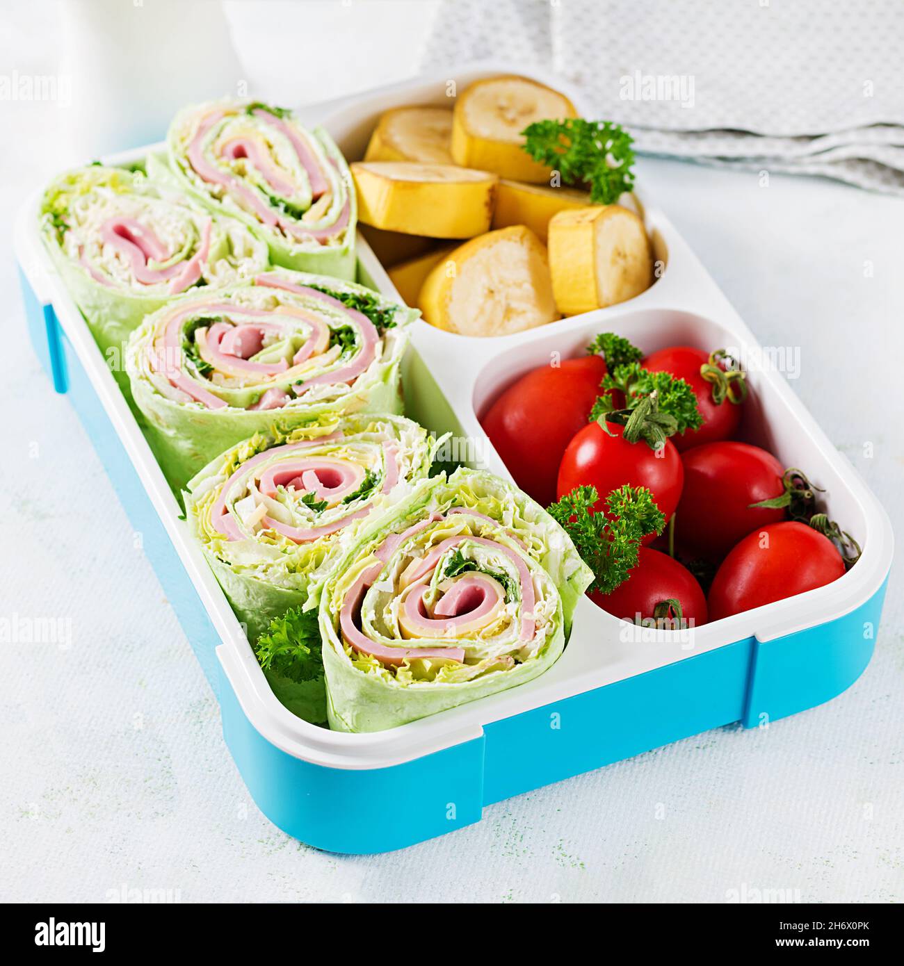 School lunchbox. Healthy lunch box with tortilla wraps, tomatoes and ...