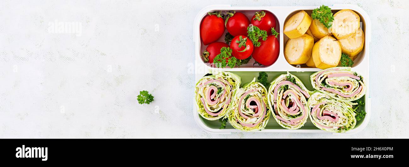 School lunchbox. Healthy lunch box with tortilla wraps, tomatoes and ...