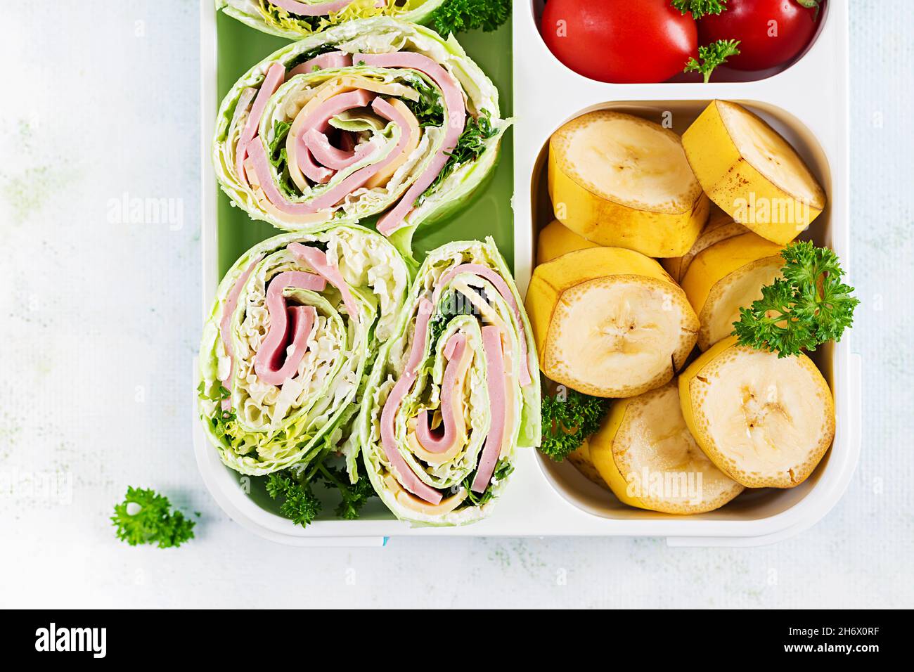 School lunchbox. Healthy lunch box with tortilla wraps, tomatoes and ...