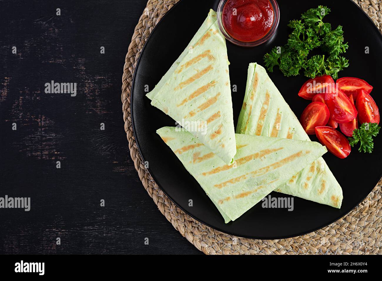 Homemade flatbread with cheese, tomatoes and green herbs. Traditional ...