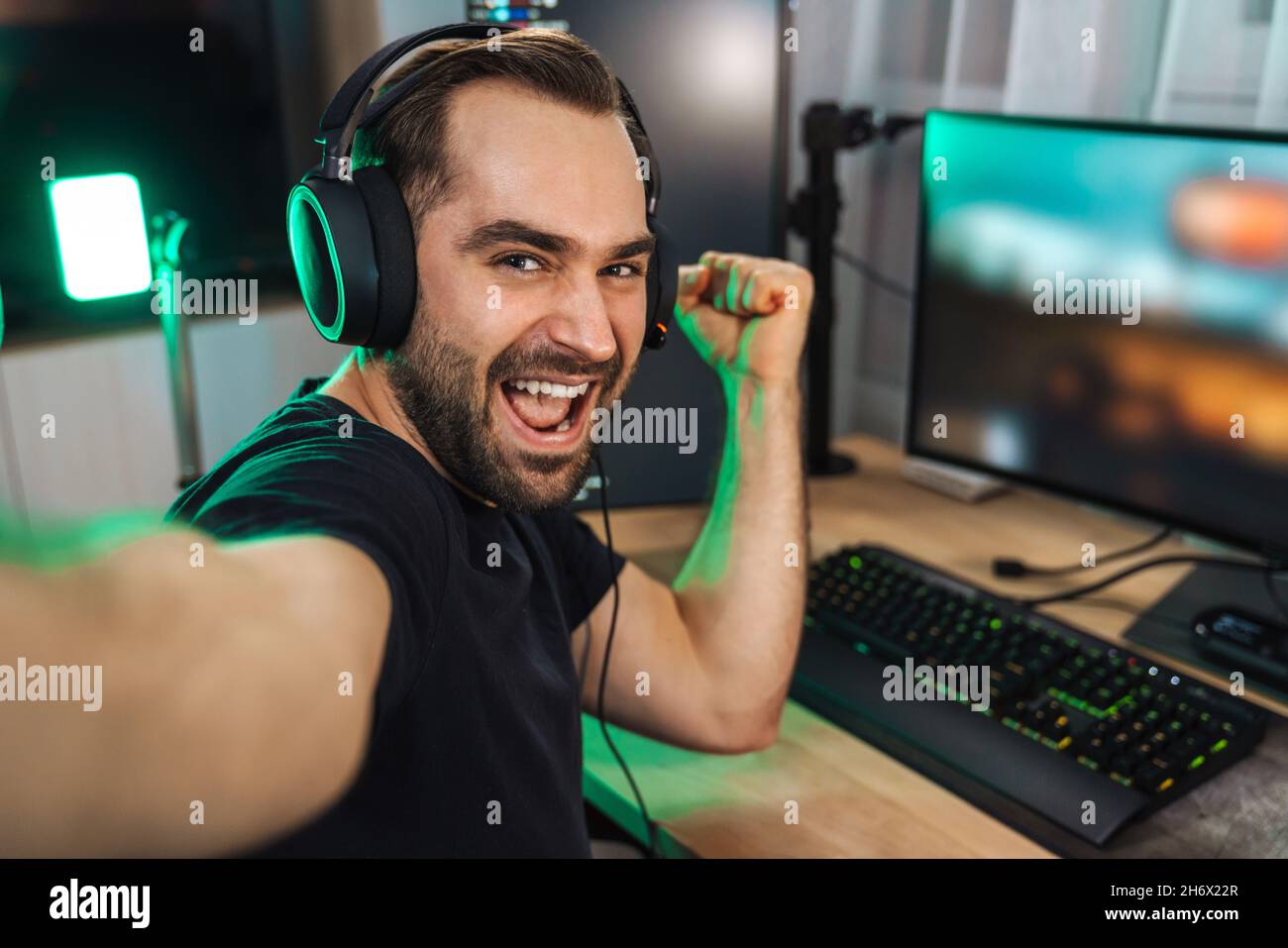 Happy young man taking selfie photo while playing video game on ...