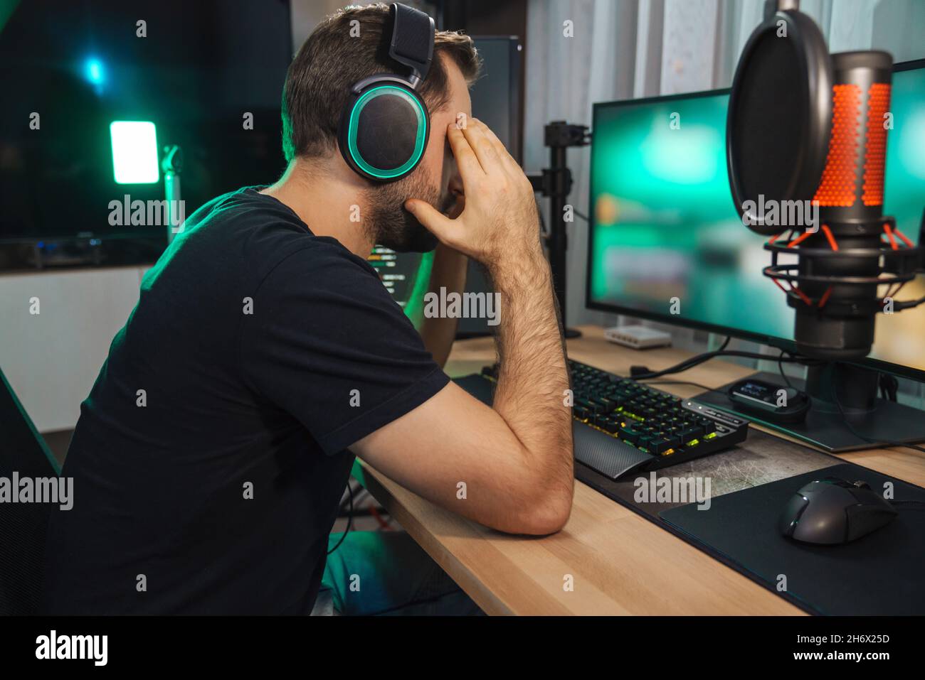Angry devastated young man gamer wearing headphones lost a game on ...