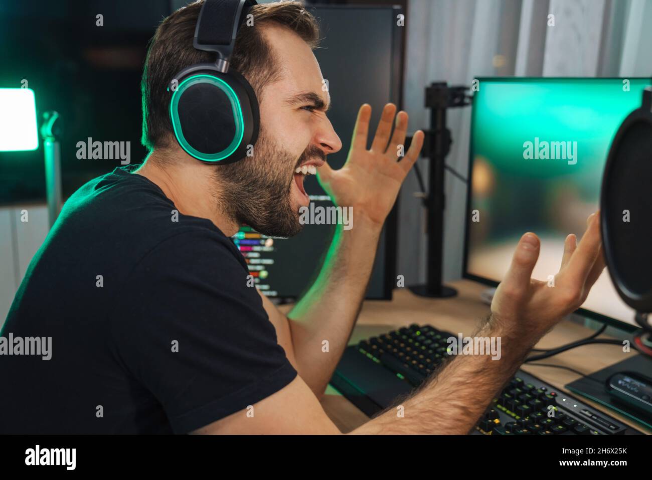 Angry devastated young man gamer wearing headphones lost a game on ...