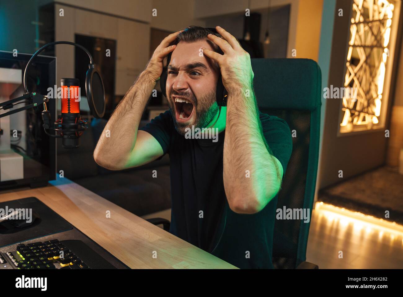 Angry devastated young man gamer wearing headphones lost a game on ...