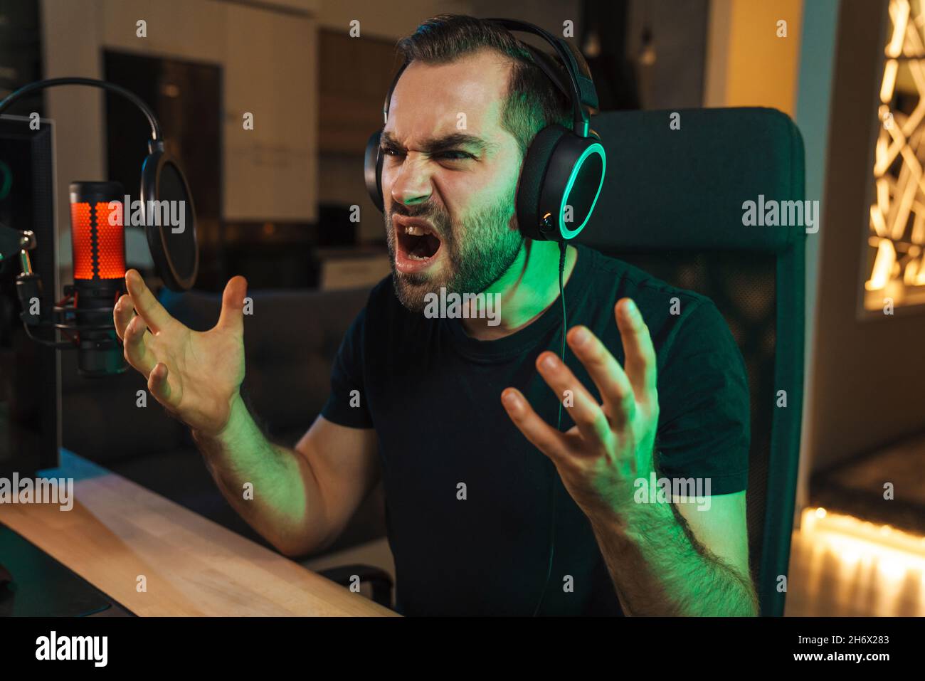 Angry devastated young man gamer wearing headphones lost a game on ...