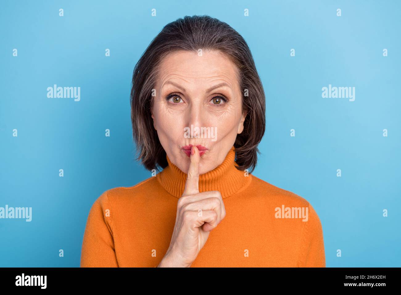 Photo of aged attractive lady finger covering lips do not tell look ...