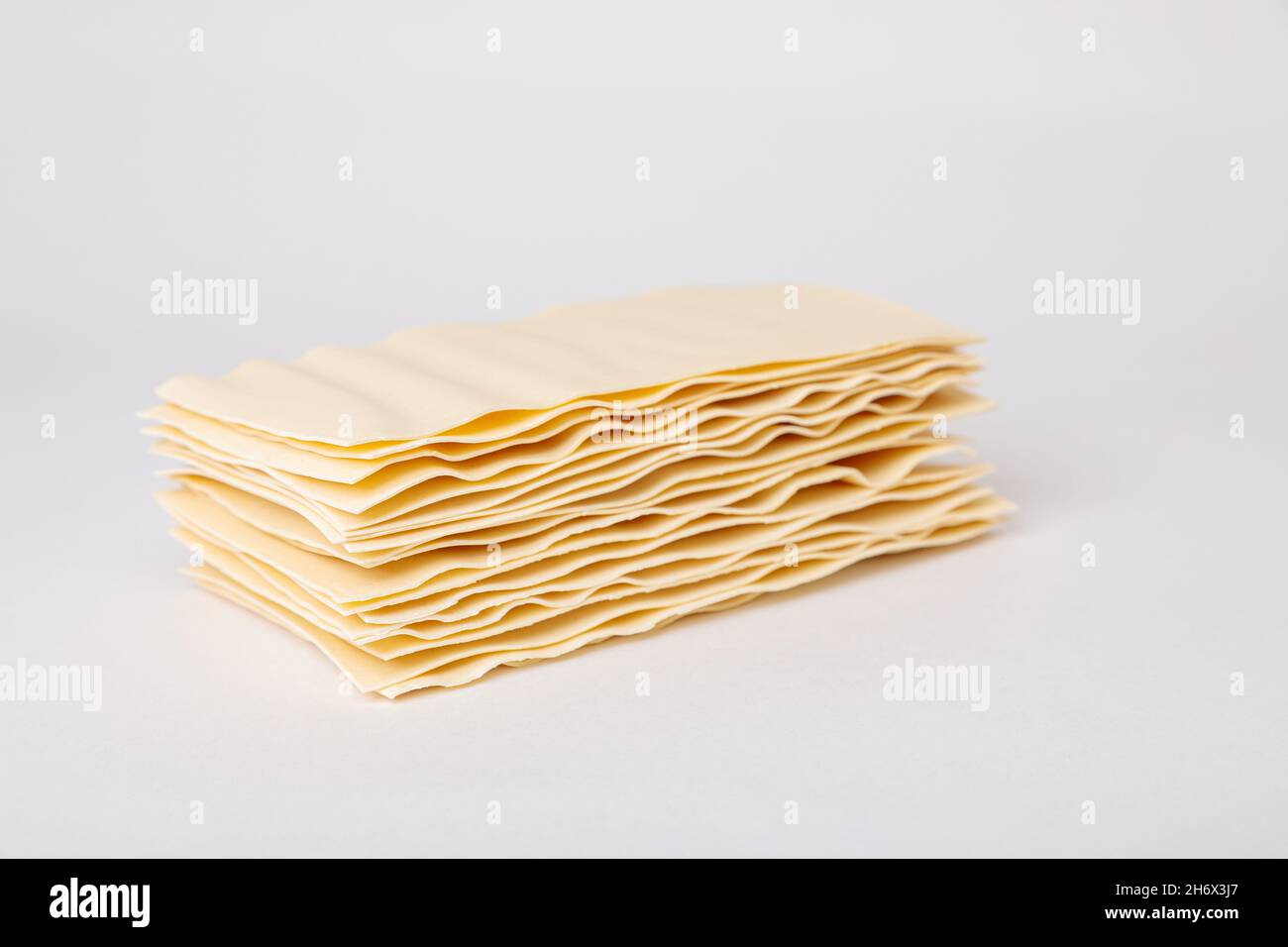 Raw lasagna. Dry dough sheets for lasagna on a white background ...