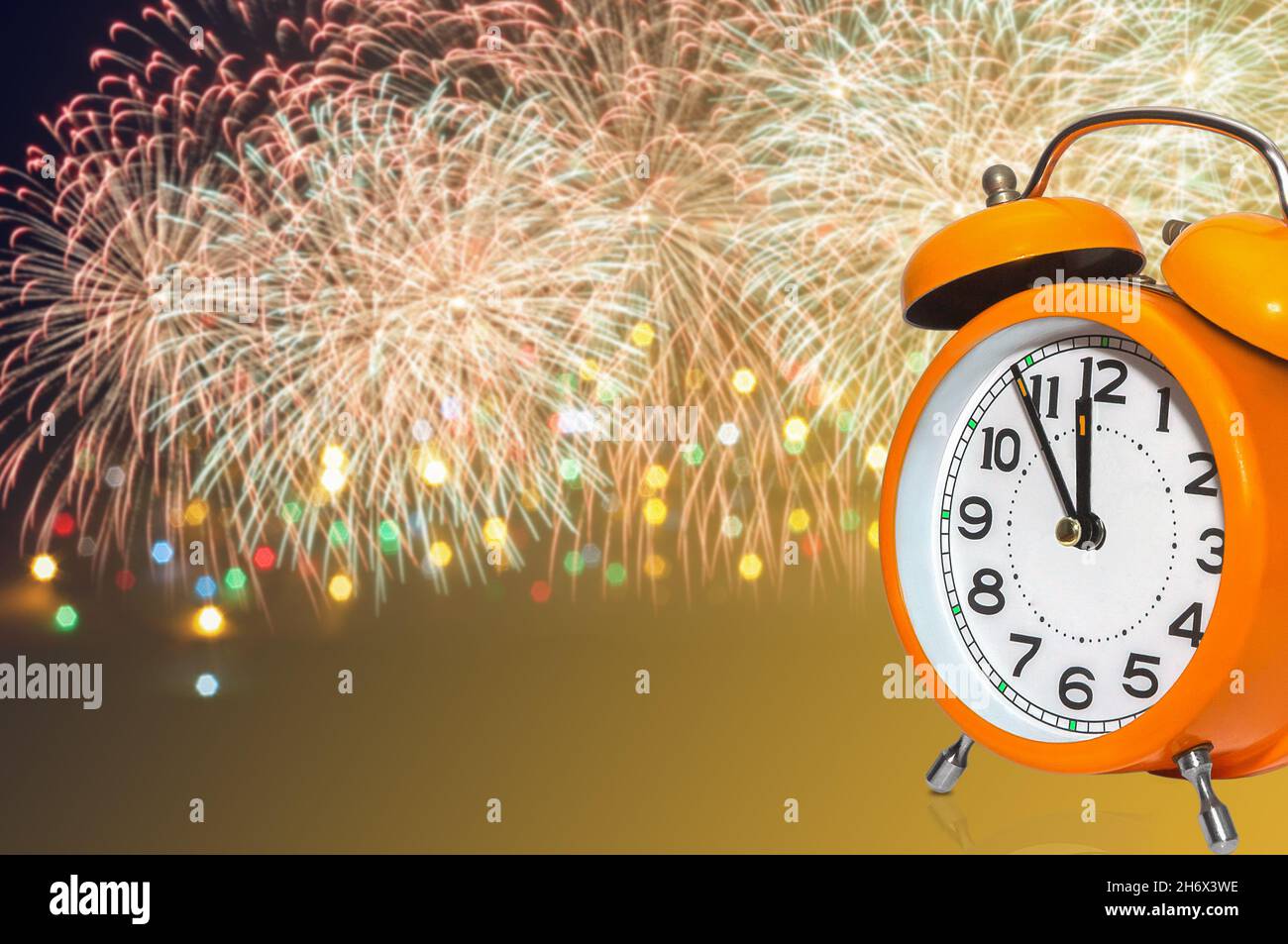 vintage alarm clock on orange background with defocused lights and ...