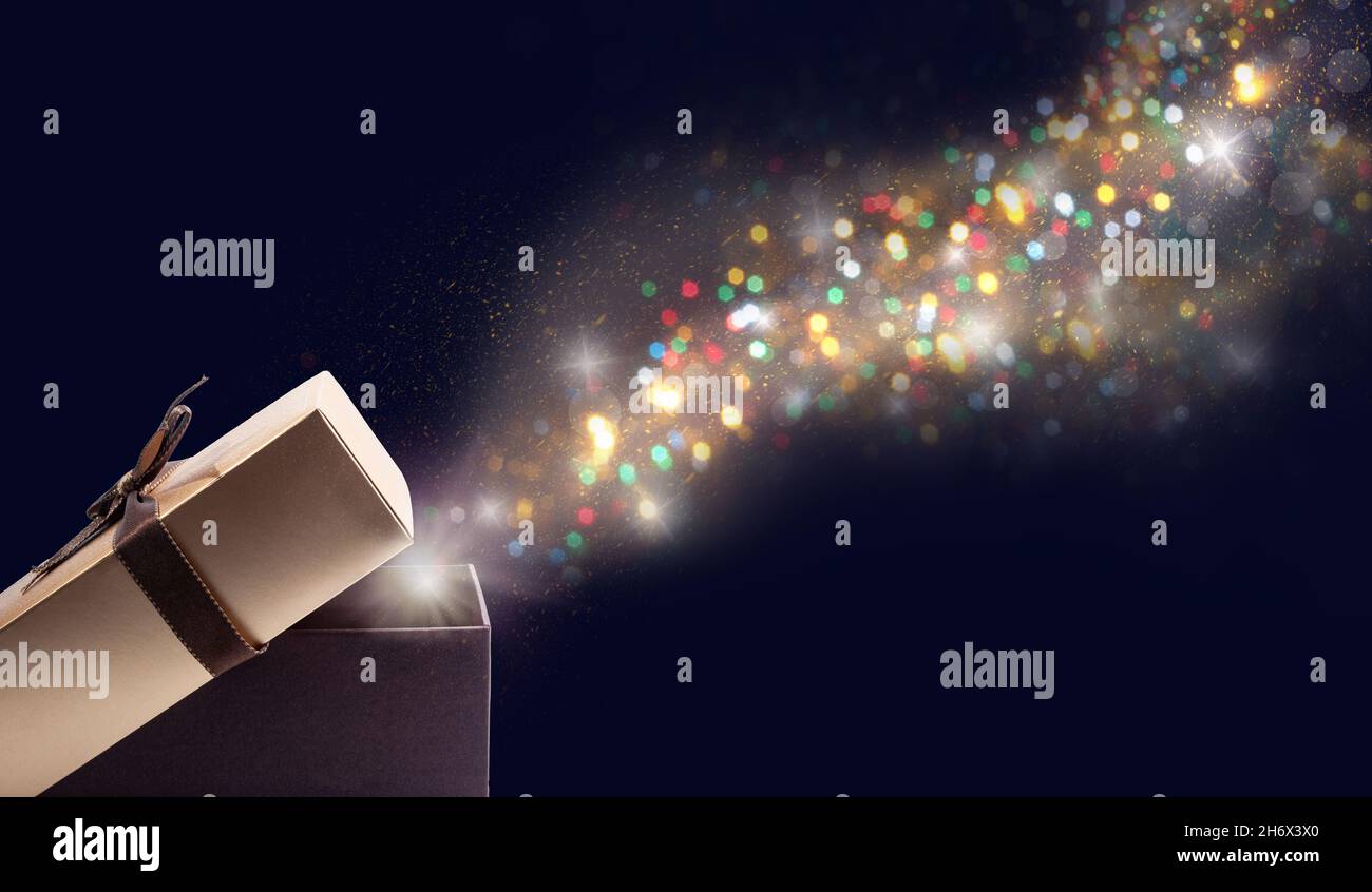 Golden open gift box with magic lights on deep dark blue background ...