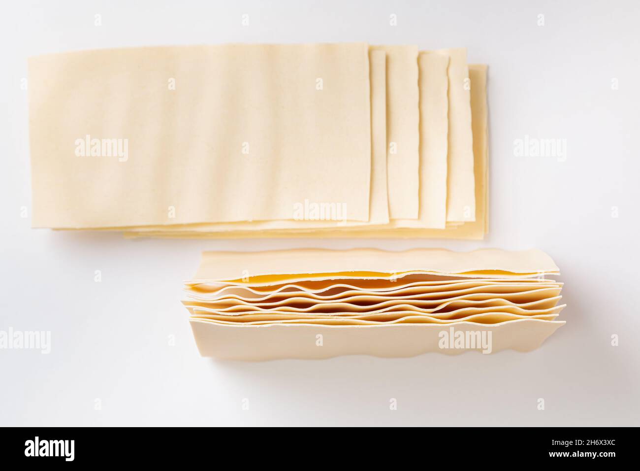 Raw lasagna. Dry dough sheets for lasagna on a white background ...
