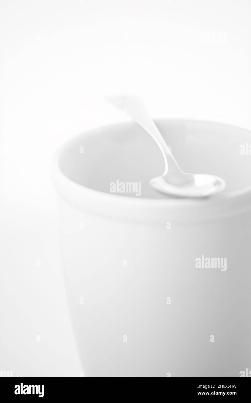 High key photo of a silver spoon lying on empty porcelain mug Stock ...