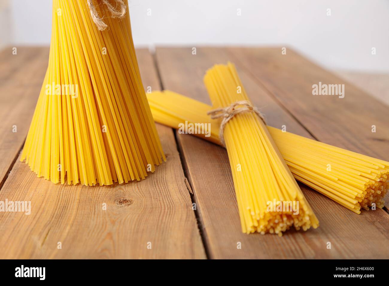 A vertical bunch and a bunch of raw spaghetti tied with string. Bundle ...