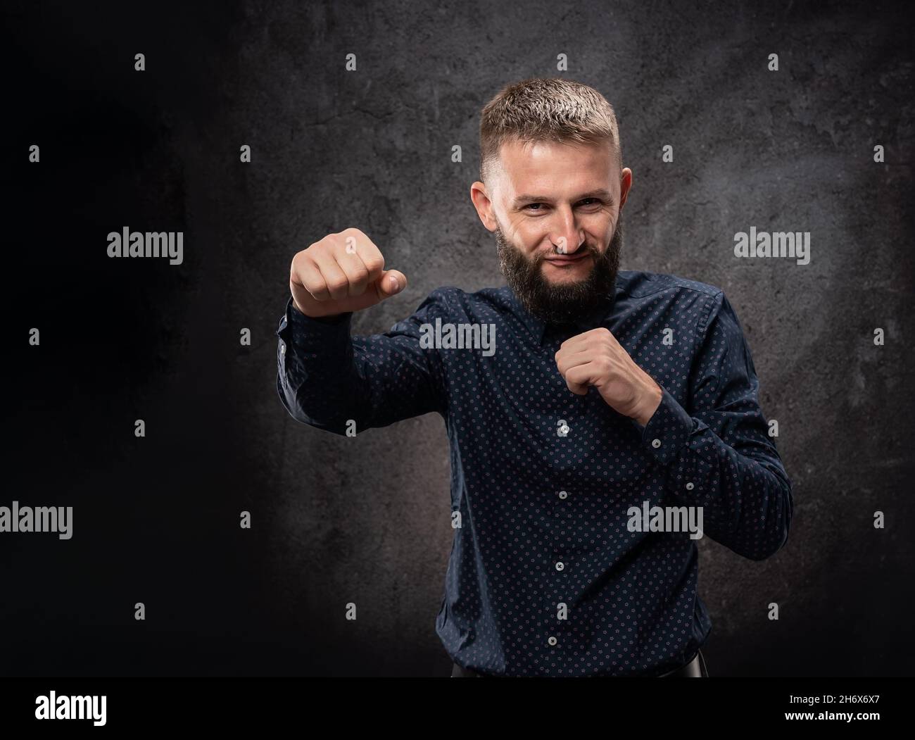 An emotional young man, a manager, imitates a punch as a winner and ...