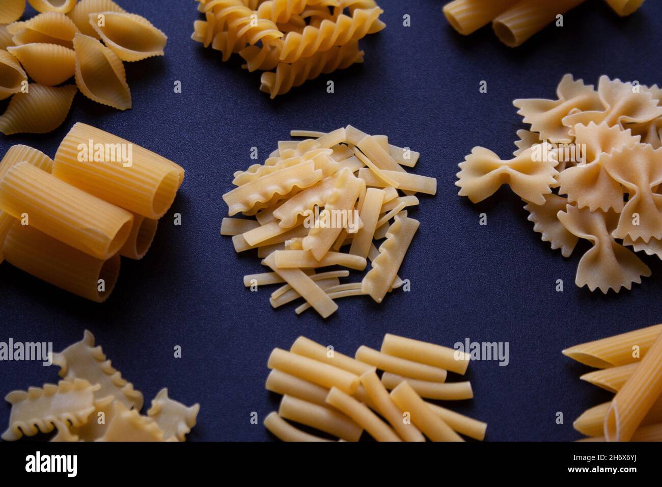 Various types of traditional Italian pasta on dark background closeup ...
