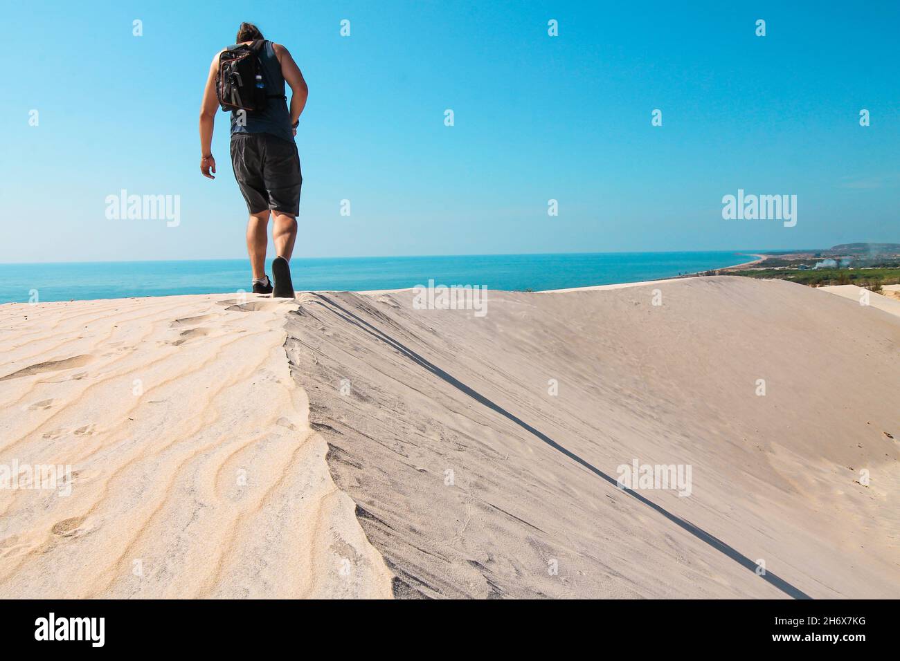 A tourist exploring the white desert dunes in Phan ri Cua, Vietnam ...