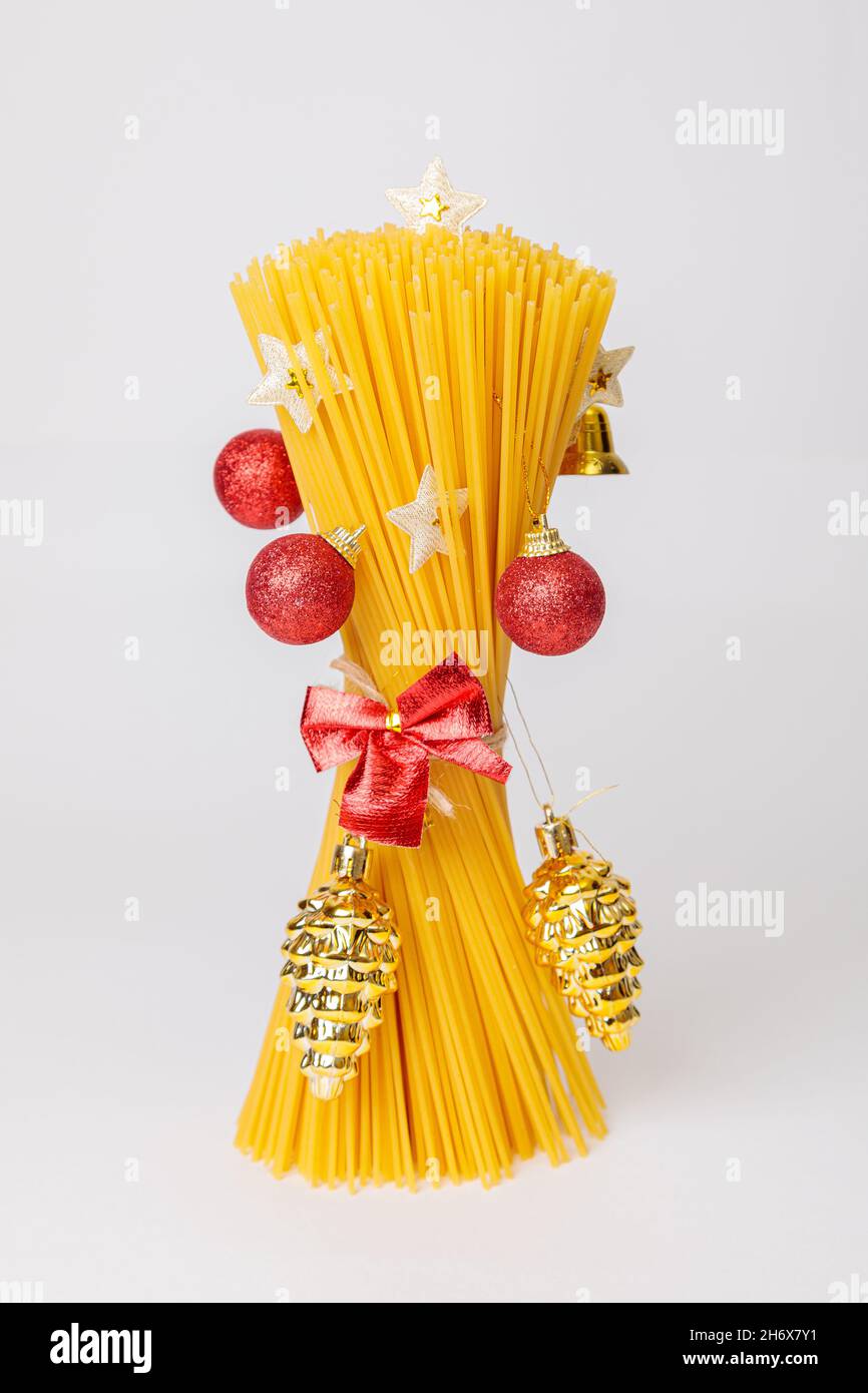 A bouquet of raw spaghetti in the shape of a Christmas tree with toys ...